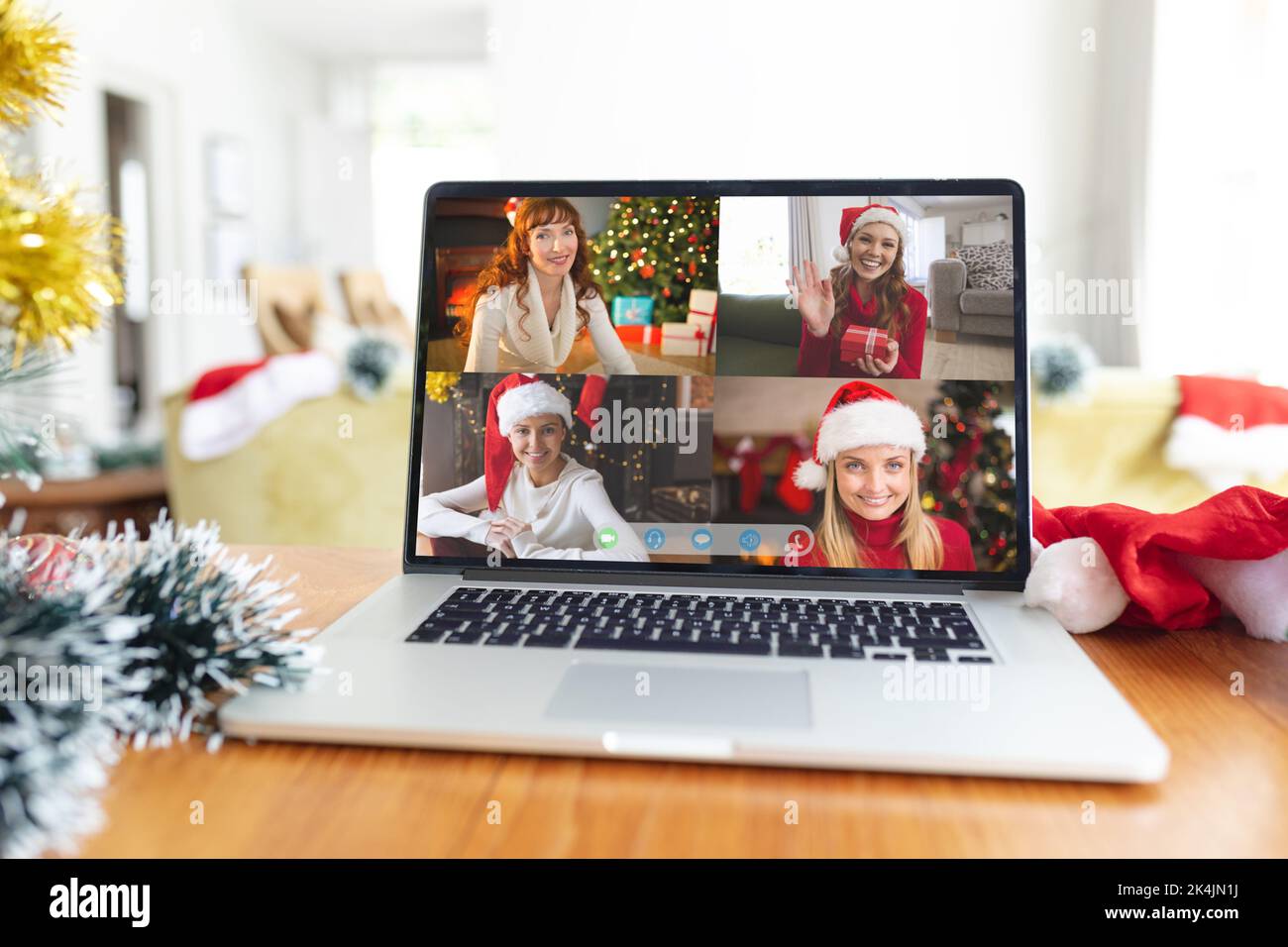 Four smiling caucasian women in santa hats on laptop christmas group ...