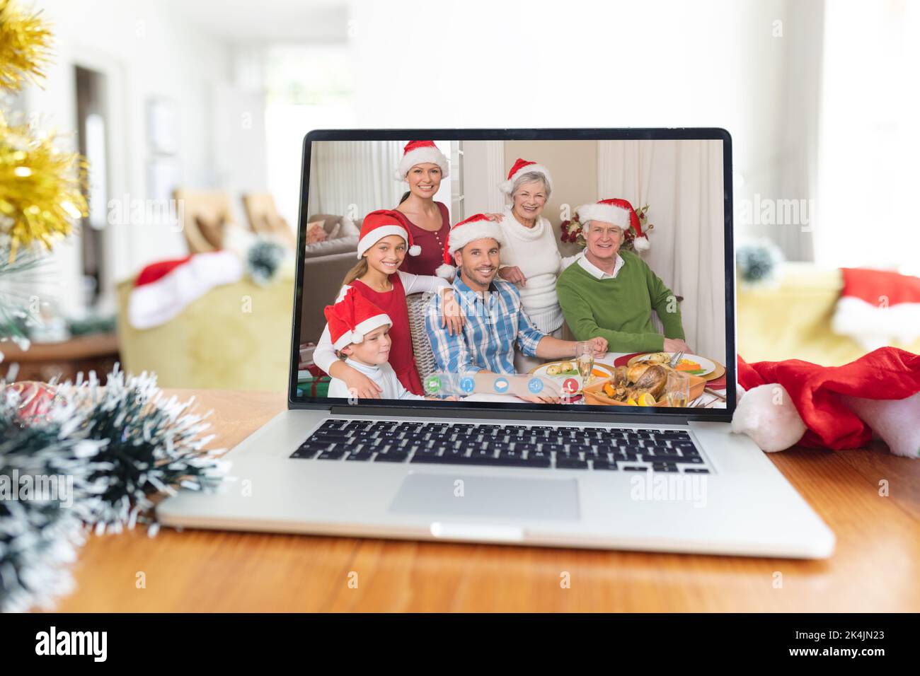 Smiling multi generation caucasian family in santa hats on laptop ...