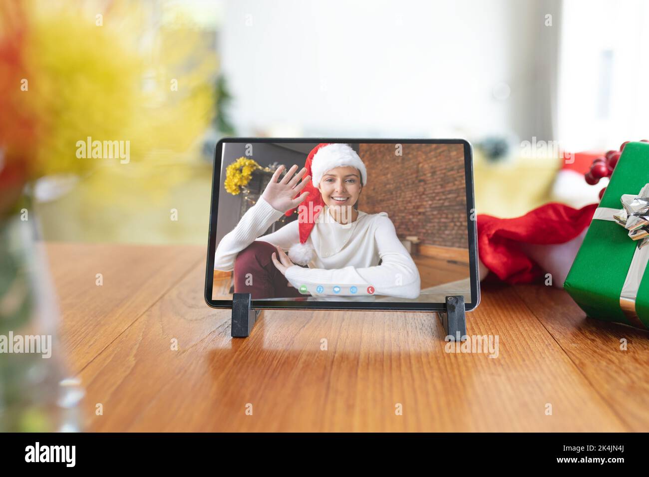 Happy caucasian woman in santa hat waving on tablet video call screen ...