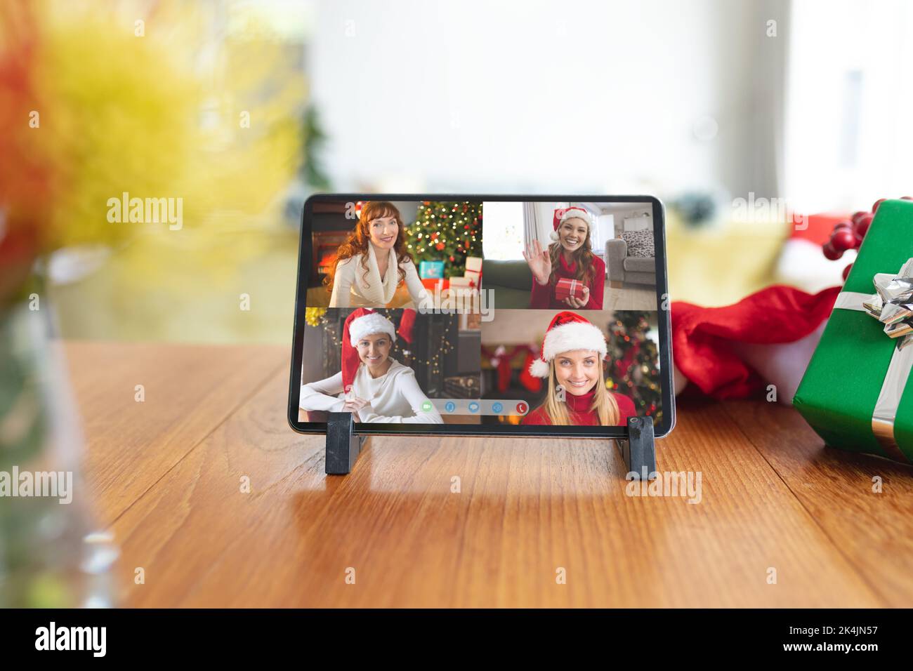 Smiling caucasian female friends in santa hats on tablet group video ...