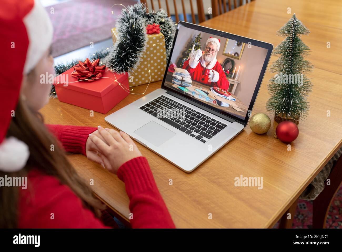 Caucasian woman in santa hat making laptop christmas video call with ...