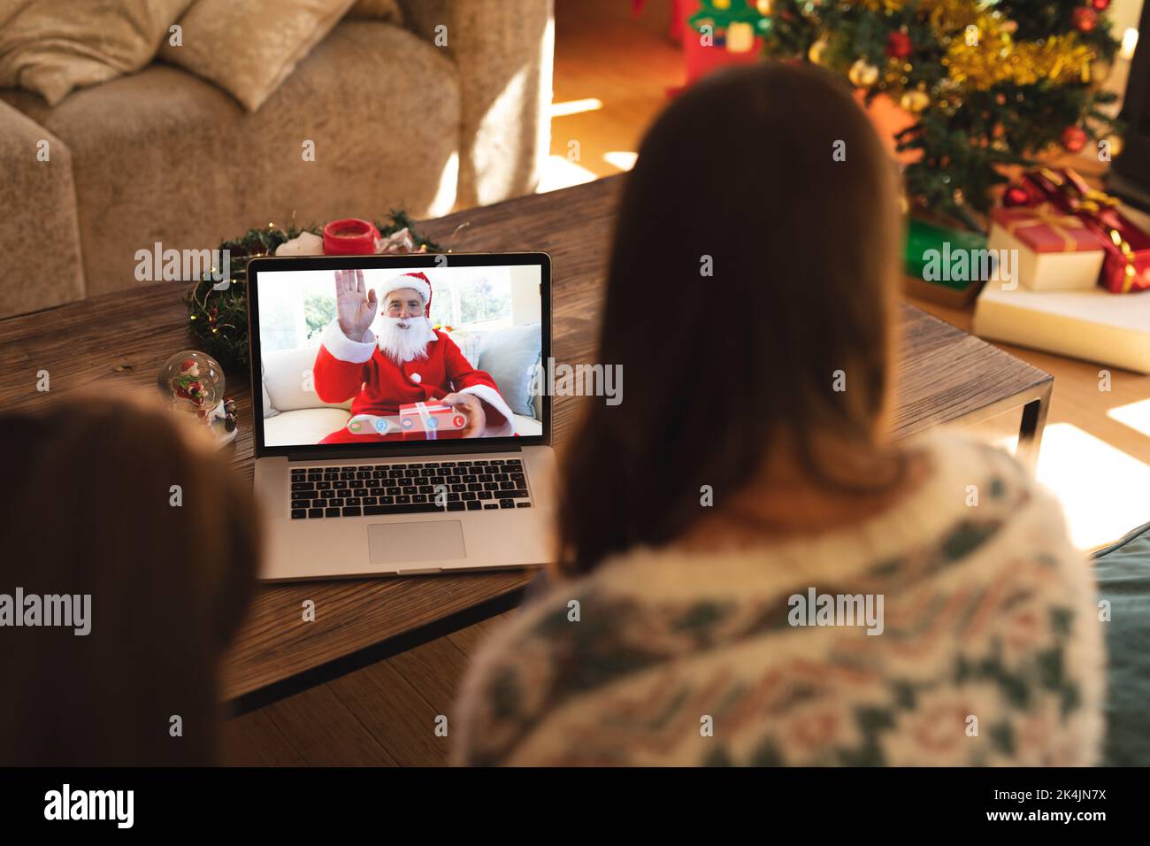 Mother and daughter making laptop christmas video call with senior ...