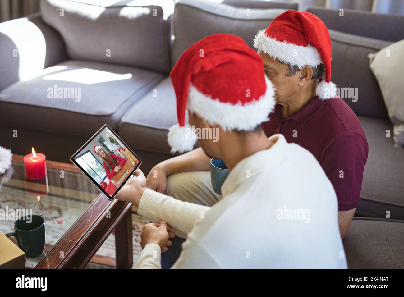 Biracial father and adult son in santa hats making laptop christmas ...