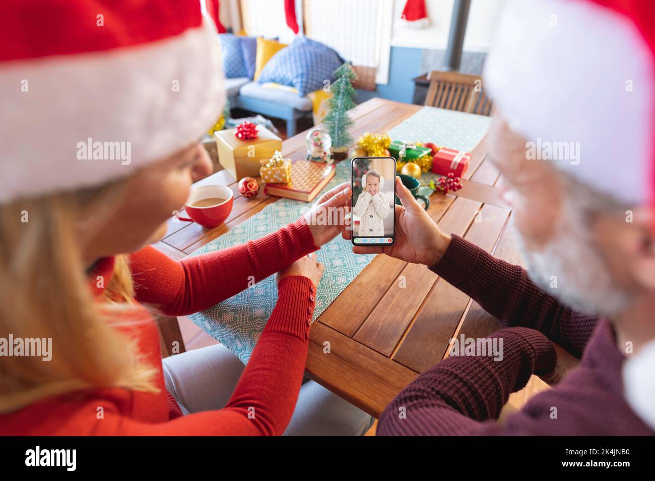 Caucasian couple in santa hats making christmas smartphone video call ...