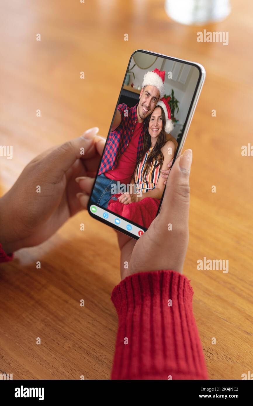 Hands of woman making smartphone christmas video call with smiling ...