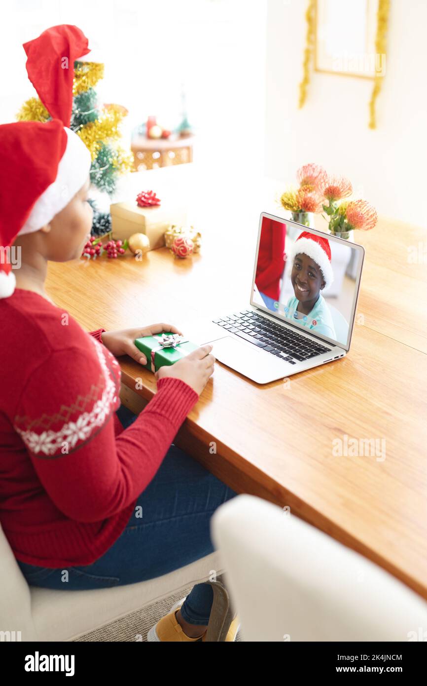 African american woman in santa hat making laptop christmas video call ...