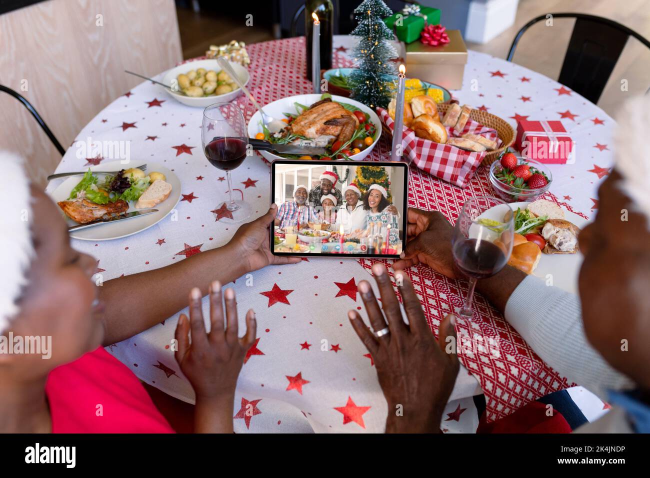 Waving african american senior couple making tablet christmas video ...