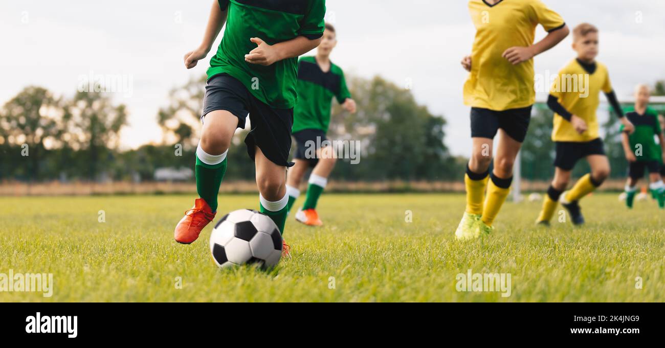 Competition between players running and kicking football ball. Young ...