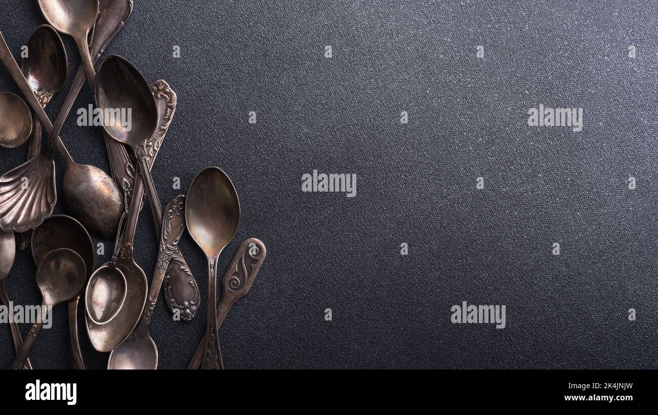 Top view of vintage silver spoons or silverware on dark concrete ...