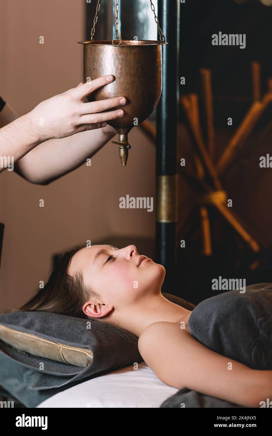 Specialist making shirodhara massage form of ayurveda therapy ...