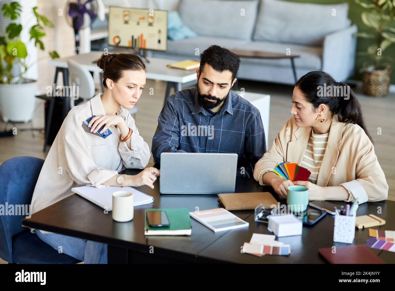Group of young confident coworkers watching online video presentation ...