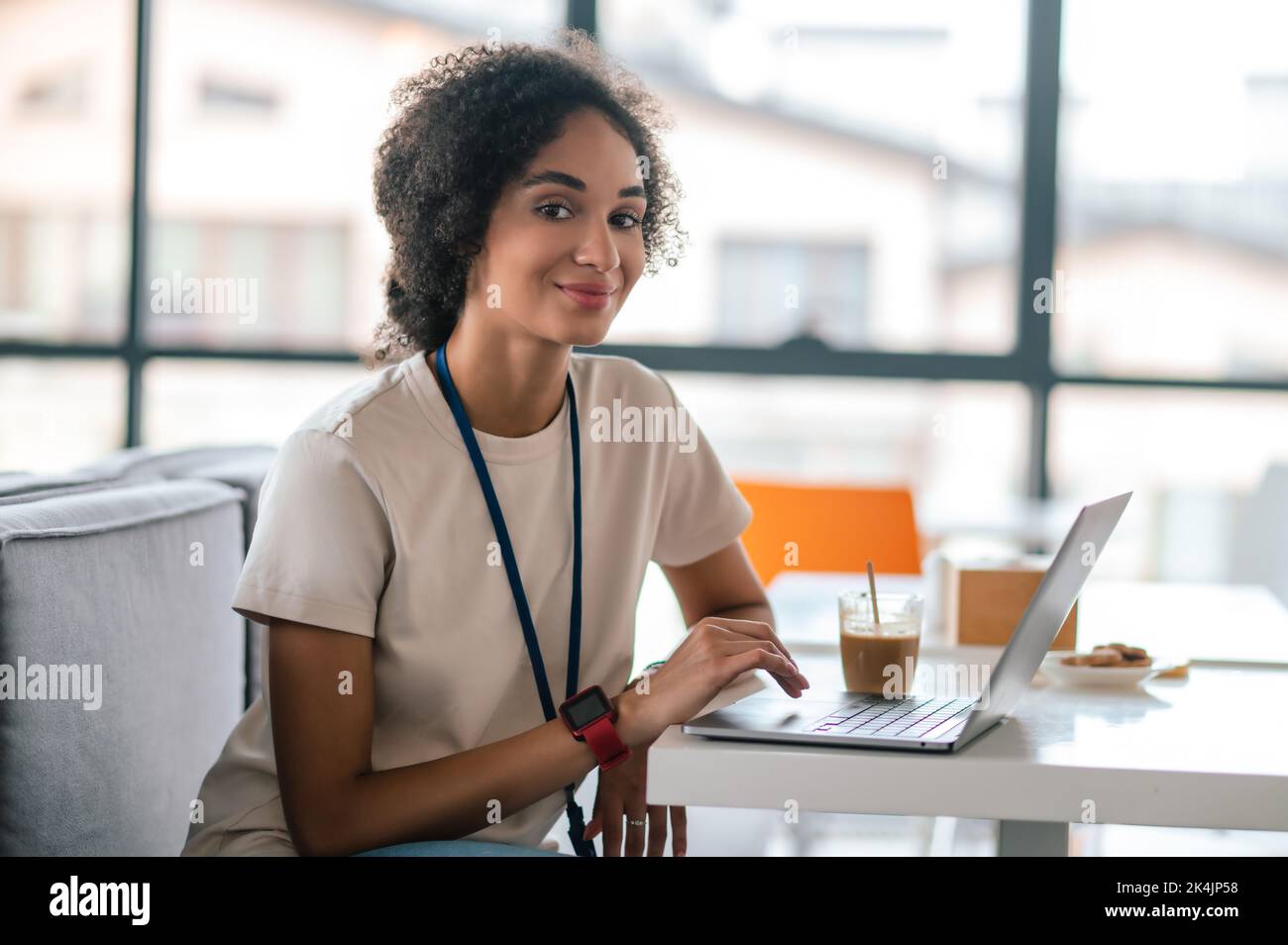 Young woman sitting at the table and working on laptop Stock Photo - Alamy