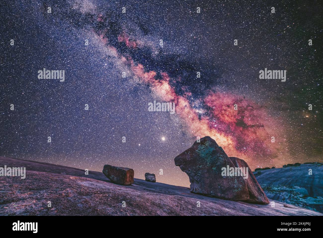 A magical scenery of rocks in the mountains under the mysterious galaxy ...