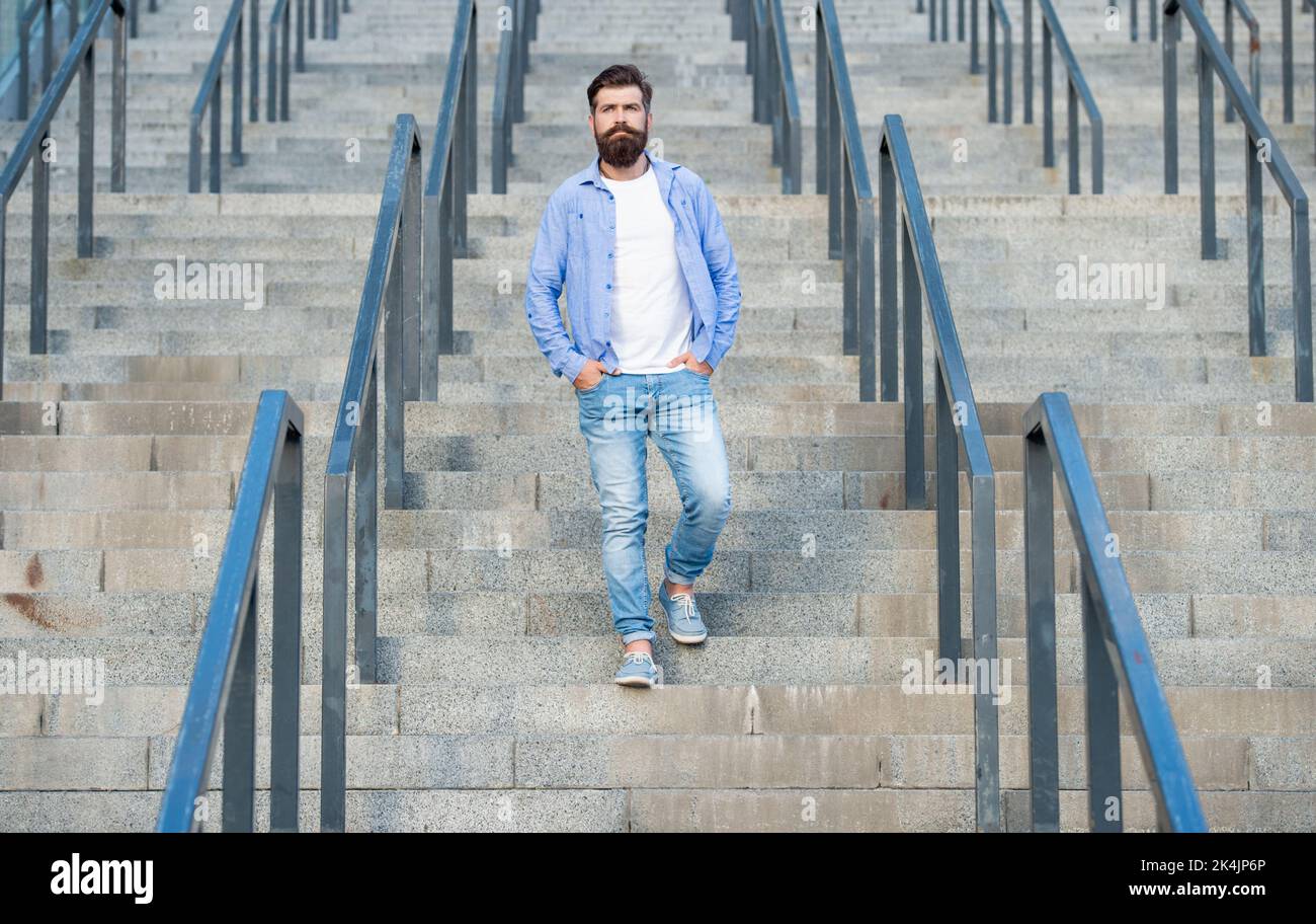 bearded man walk downstairs. full length of man with beard. hipster man outdoor go down stairs ...