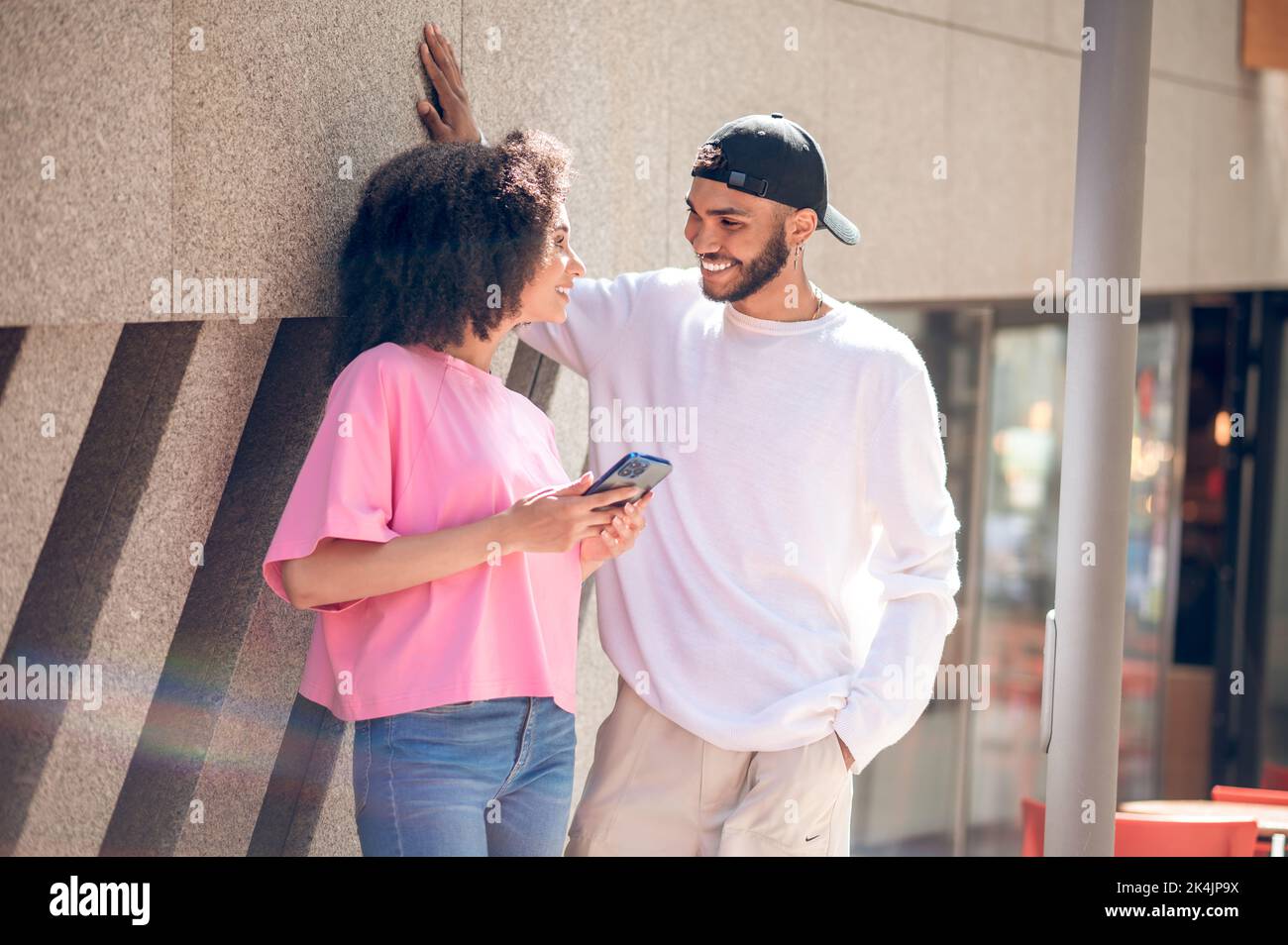 Young people standing near the wall and talking Stock Photo - Alamy