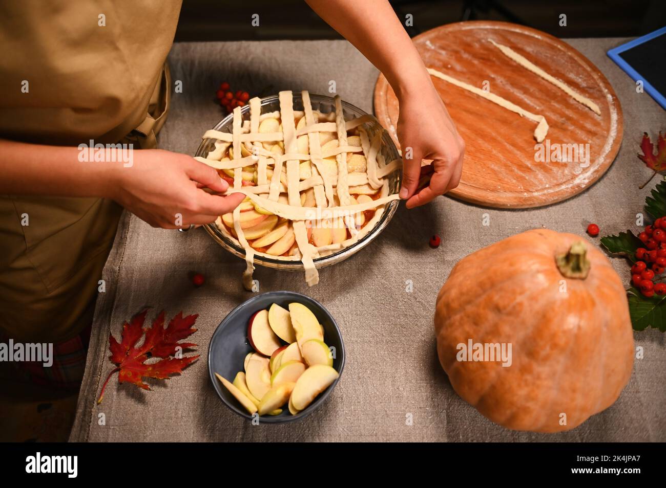 Top view of housewife decorating the festive homemade pumpkin apple pie ...