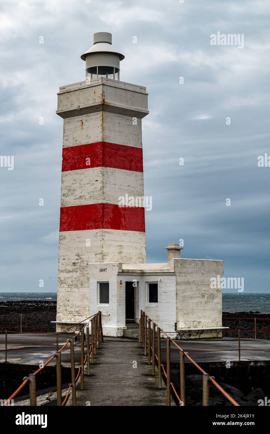 The old Garðskagi lighthouse in Garður under a cloudy sky, Reykjanes ...