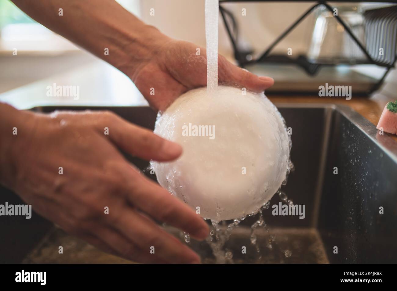 Man in the kitchen washing the dishes and doing some housework Stock ...