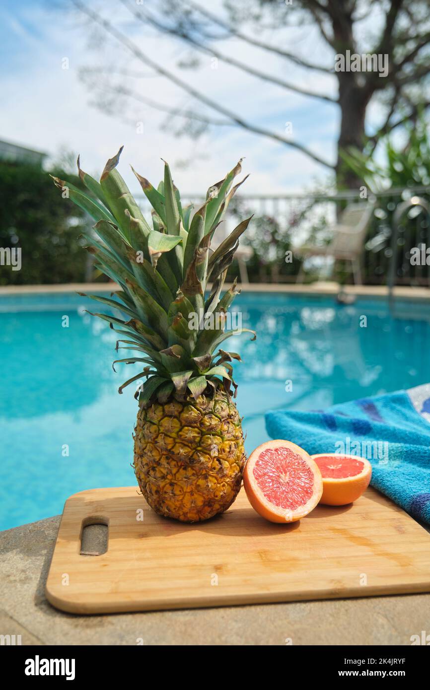 pineapple and grapefruit on the edge of the pool Stock Photo - Alamy