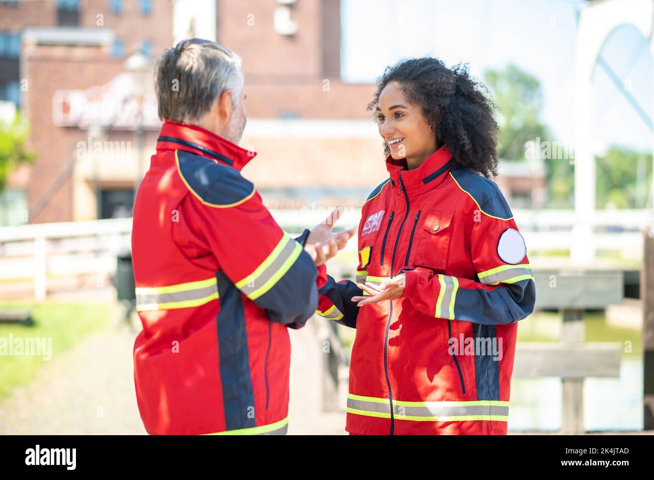 Paramedical personnel dressed in red uniforms standing outdoors Stock ...