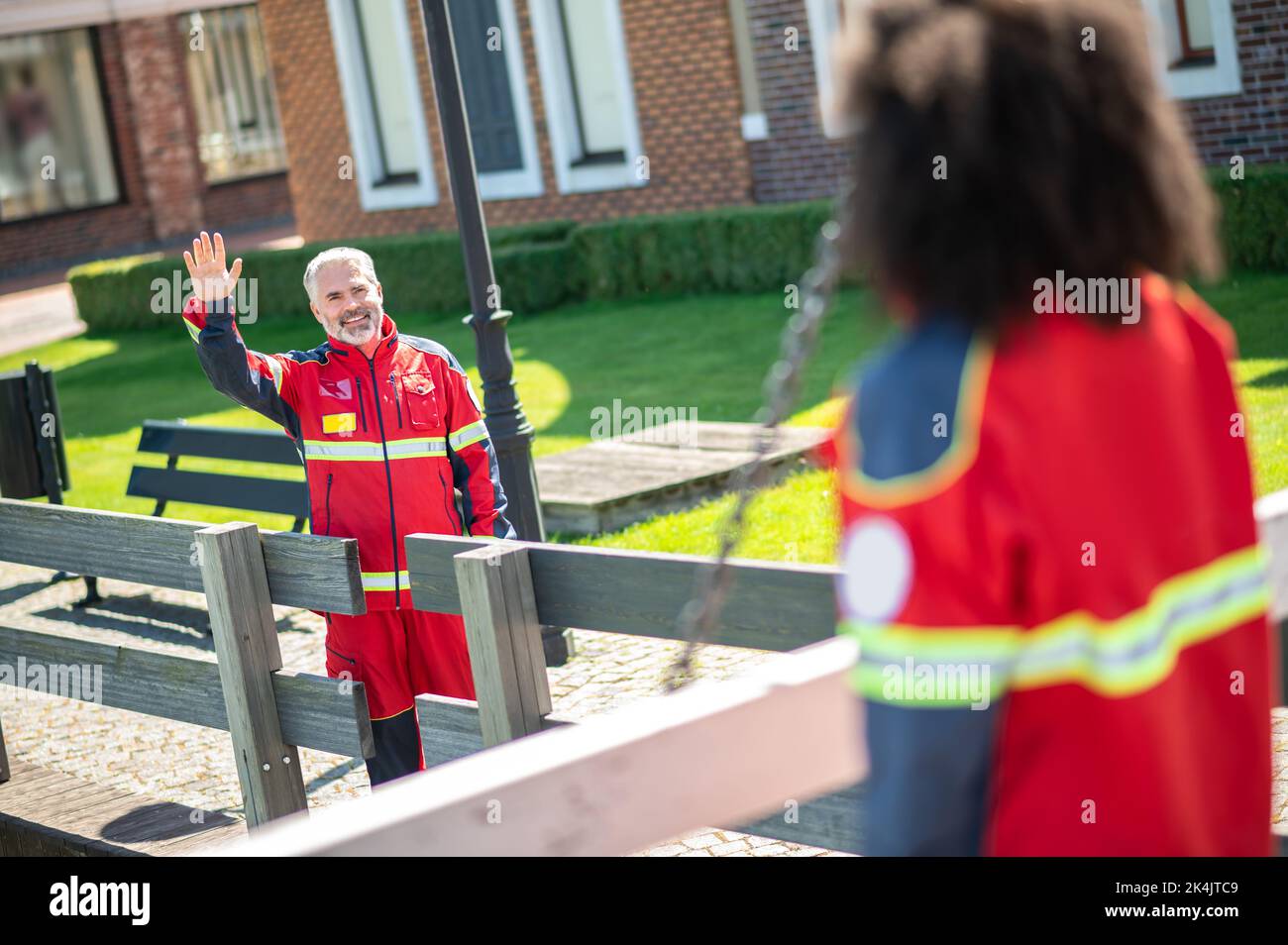 Joyous paramedical professional greeting a coworker outdoors Stock ...