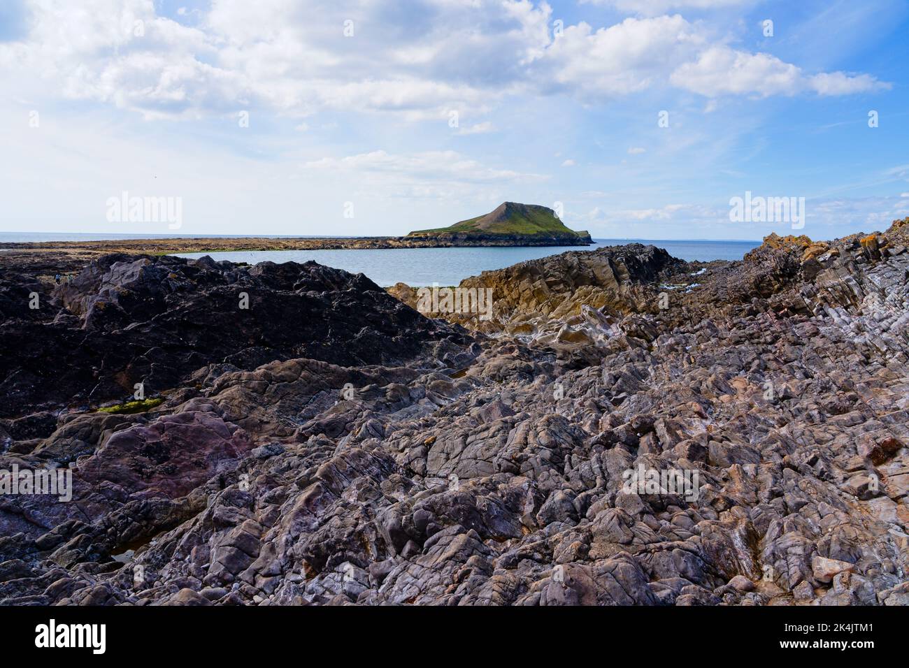 Low tide exposes the rocky causeway from Rhossili Point to the Worms Head promontory Stock Photo ...