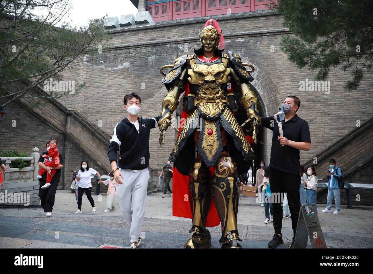 XI'AN, CHINA - OCTOBER 1, 2022 - Tourists pose with a 2.7-meter-tall mecha "Warrior" cruising at ...