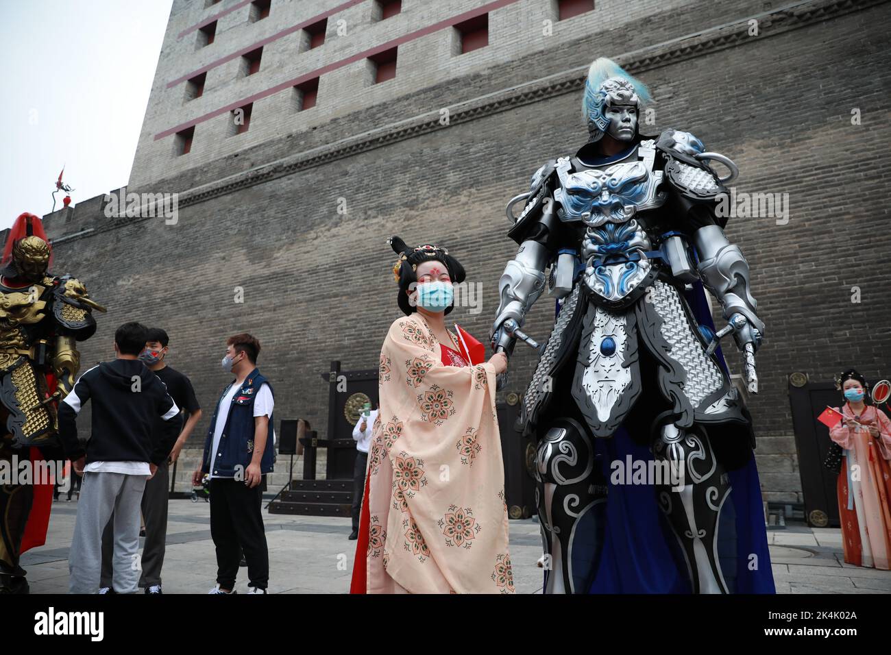 XI'AN, CHINA - OCTOBER 1, 2022 - Tourists pose with a 2.7-meter-tall mecha "Warrior" cruising at ...
