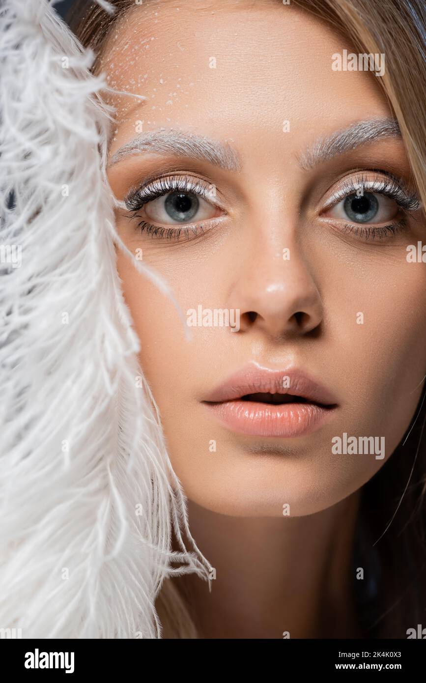 portrait of pretty young woman looking at camera while posing with ...