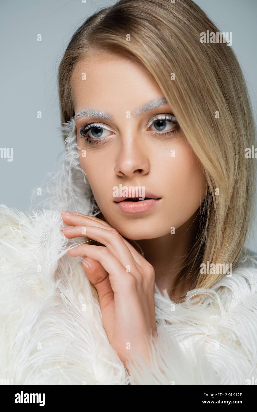 portrait of young woman with winter makeup and white eyebrows posing ...
