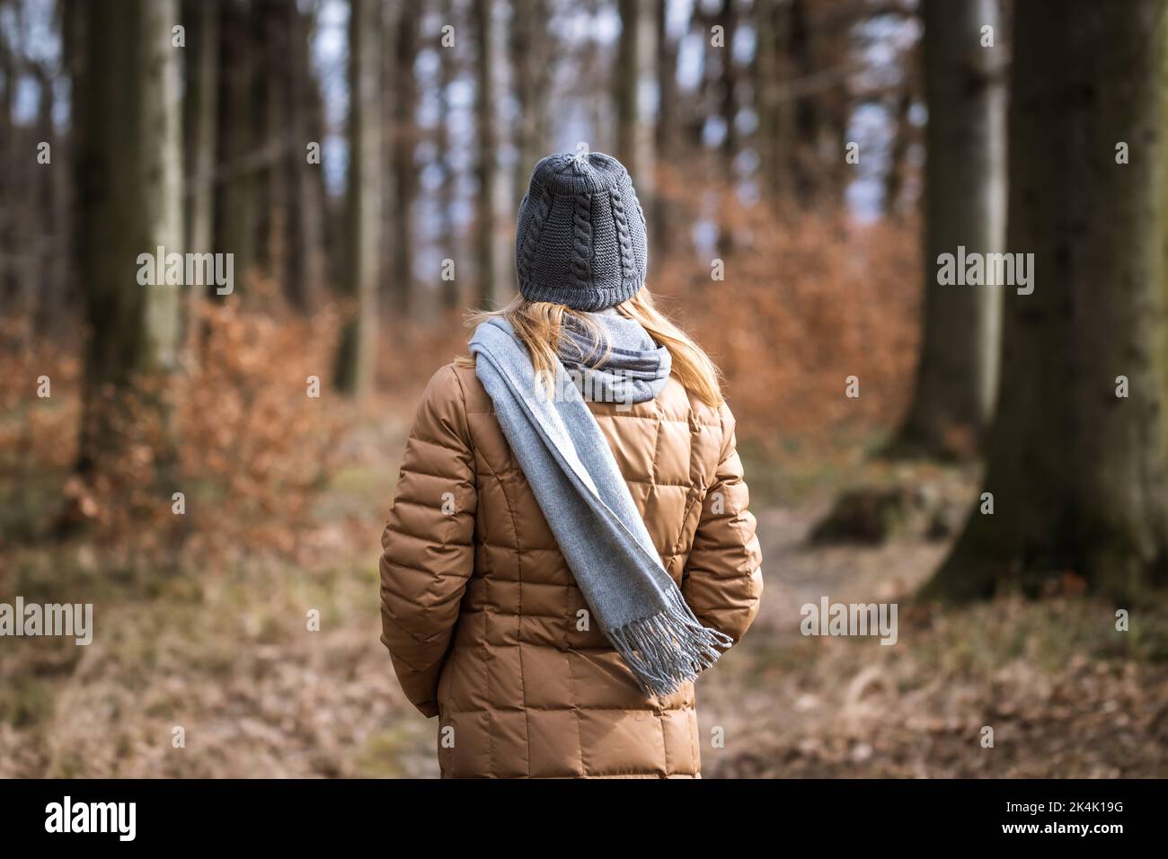 Woman wearing warm clothing in cold autumn weather. Walk in forest at ...