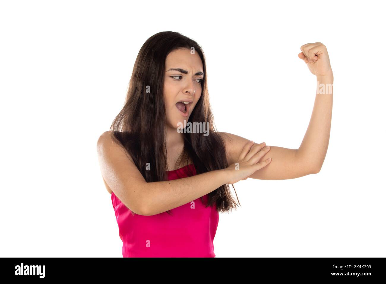 Strong powerful brunette woman with raises arms and shows biceps, wears ...