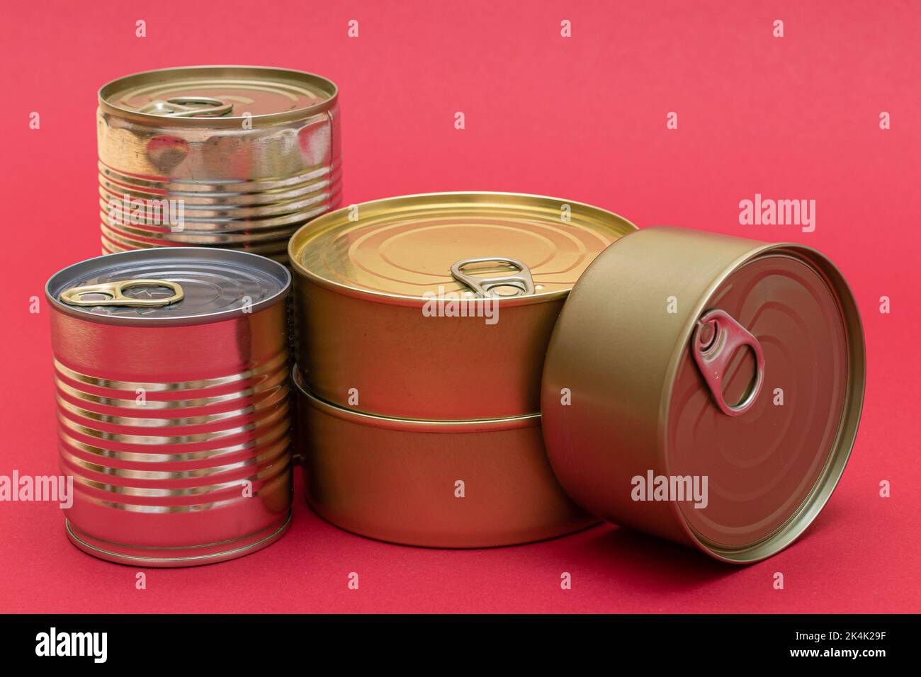 A Group of Stacked Tin Cans with Blank Edges on Red Background. Canned ...