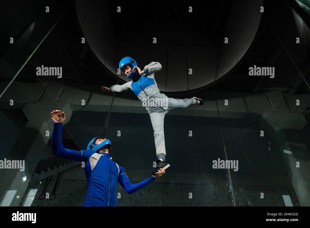A man teaches a woman how to fly in a wind tunnel. Free fall simulator ...