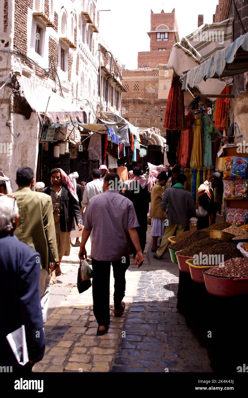 Shoppers walking through a narrow alleys of the old city bazaar, Sanaa ...