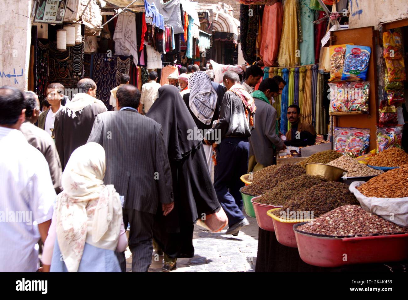Shoppers walking through the narrow alleys of the old city bazaar ...