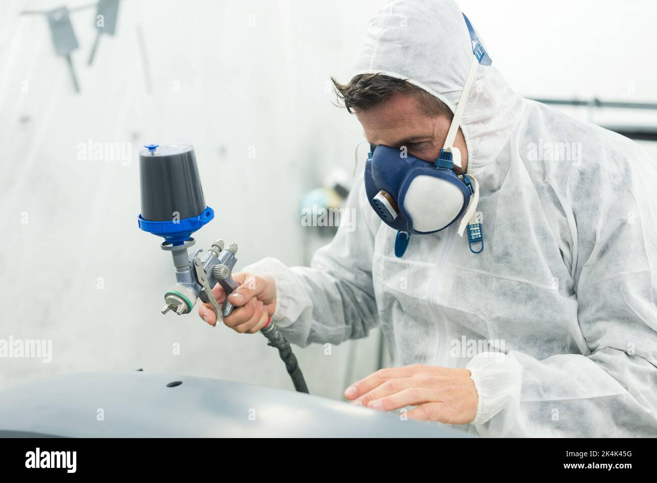 worker man spray painting on car body part in car Stock Photo - Alamy