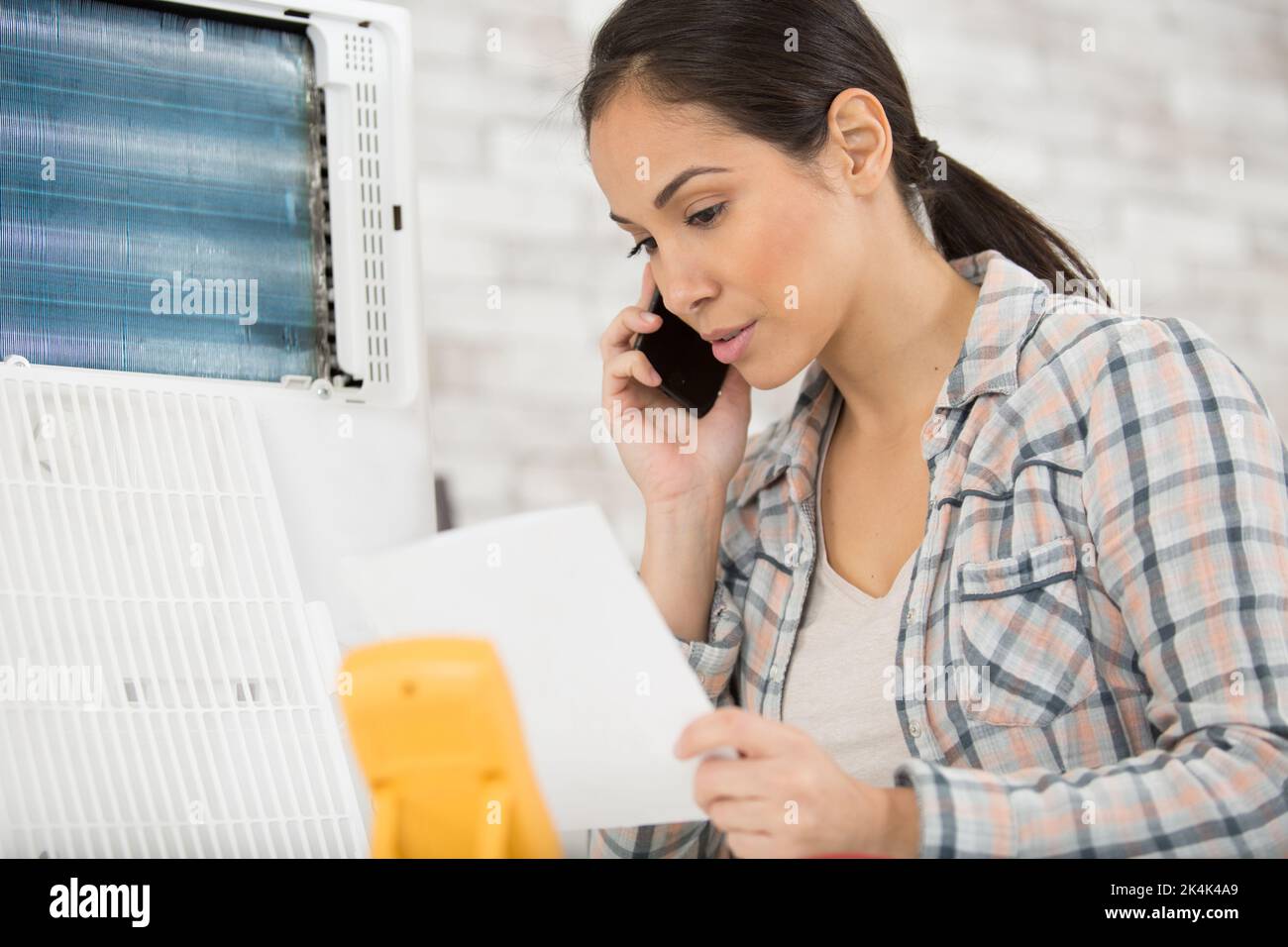 female worker on the phone fixing a device Stock Photo - Alamy
