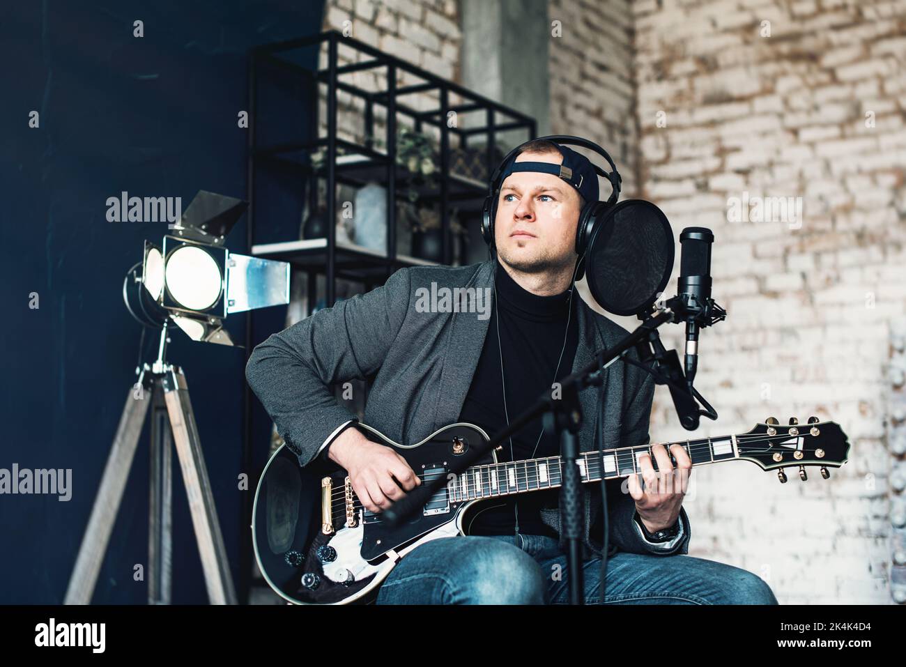 Close up of a man singer sitting on a stool in a headphones with a ...