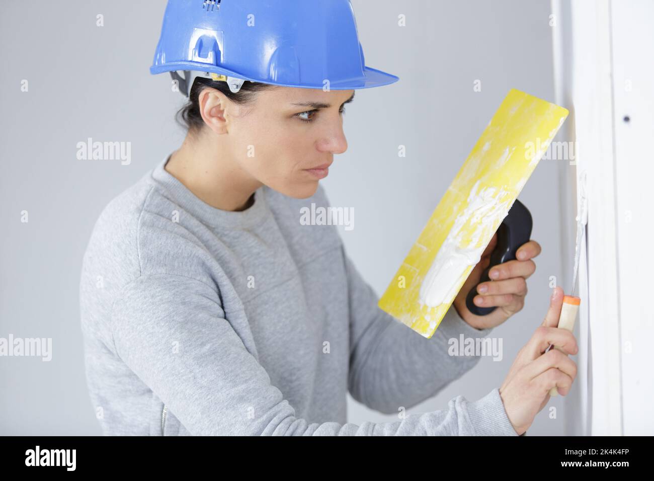 working woman plastering painting walls inside the house Stock Photo ...