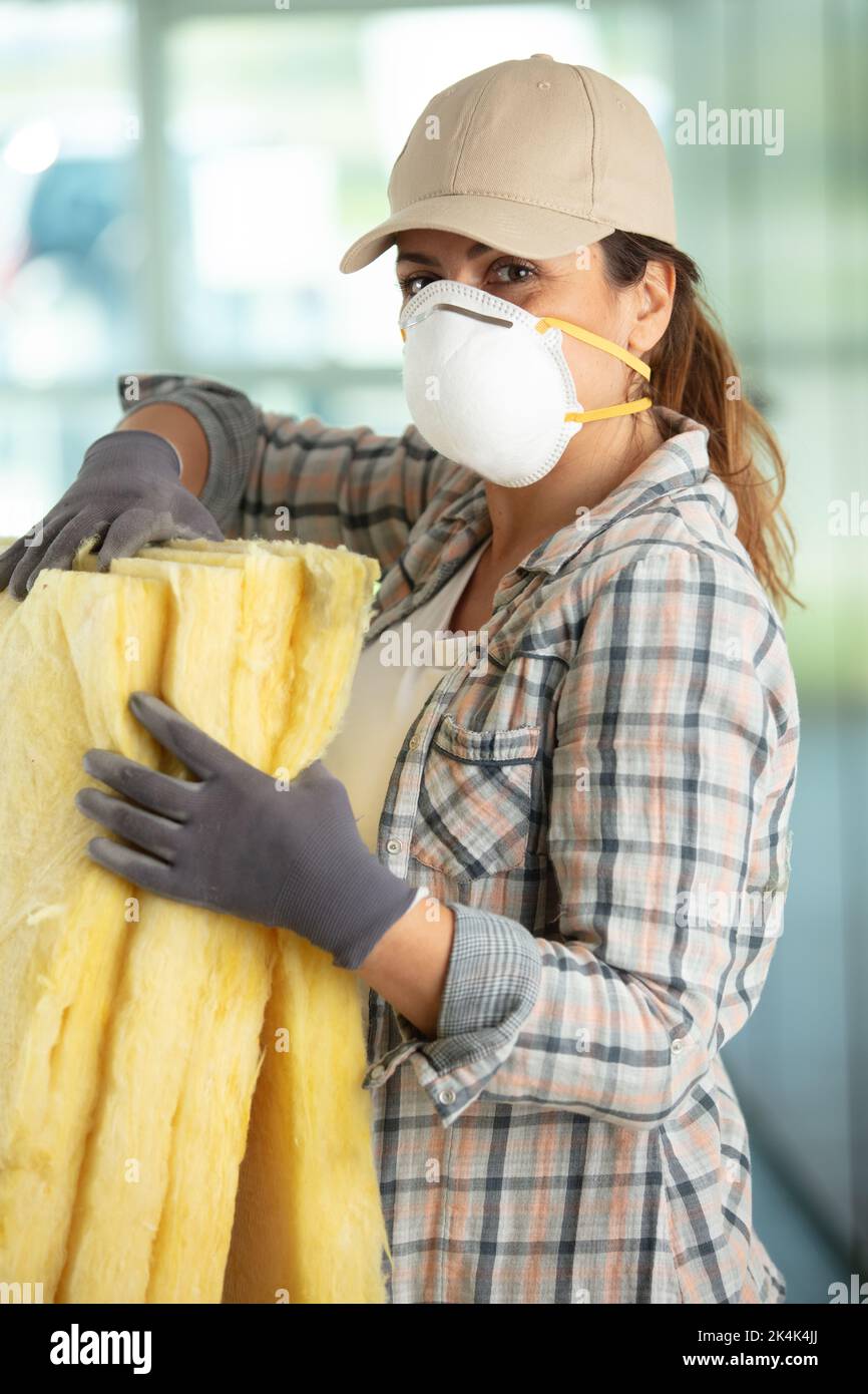 female worker wearing mask while handling insulation Stock Photo - Alamy