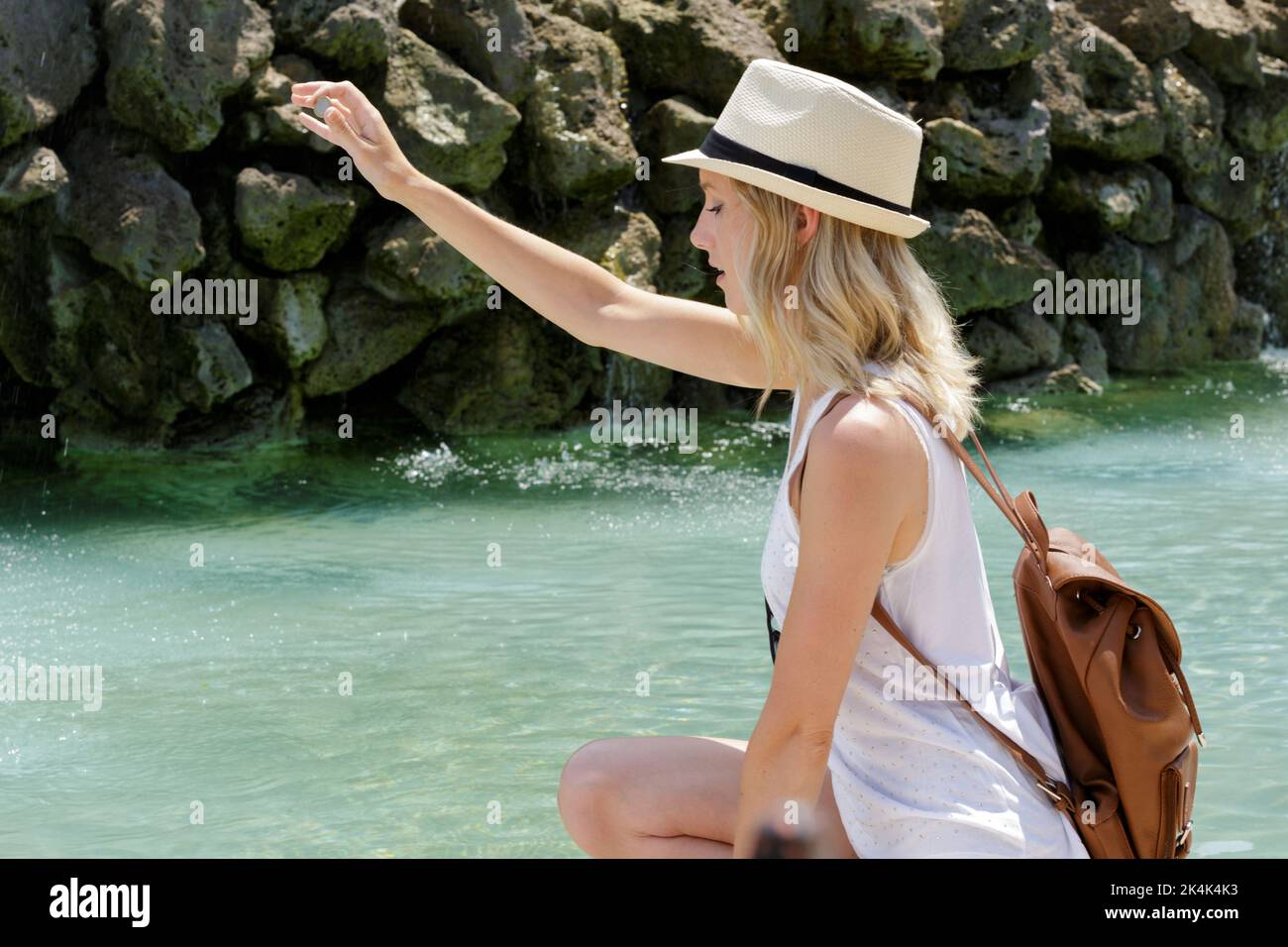 woman throwing coin in a fountain Stock Photo - Alamy