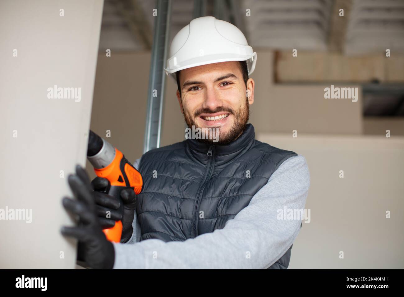 portrait of smiling male builder using a cordless drill Stock Photo - Alamy