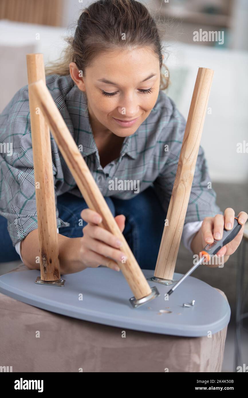Young DIY woman grinding and polishing a table with a grinder Stock ...