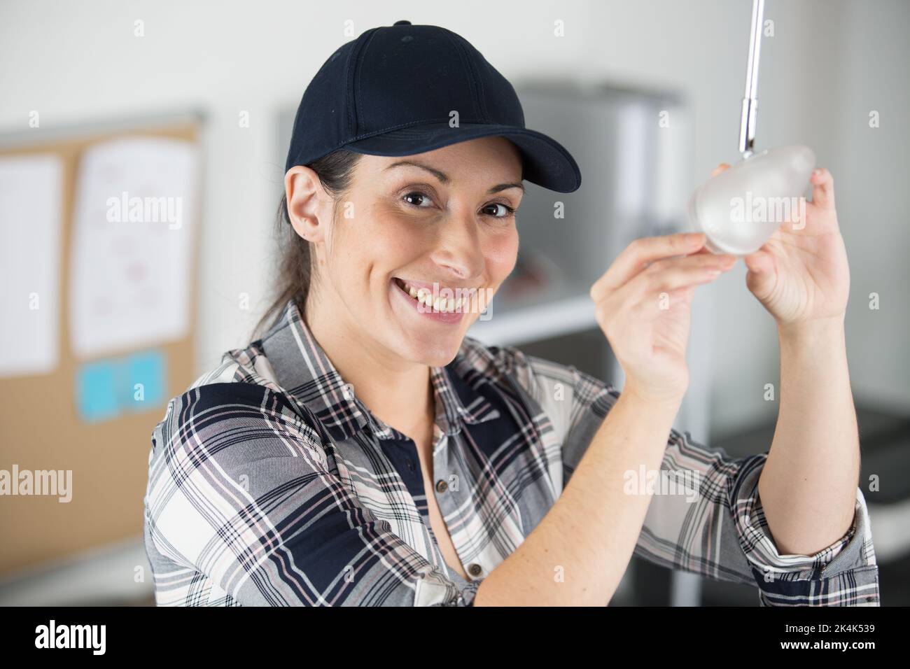 a woman changing a lightbulb Stock Photo - Alamy
