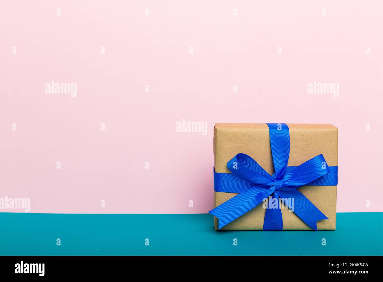 holiday handmade paper present tied blue ribbon bow top view with copy ...