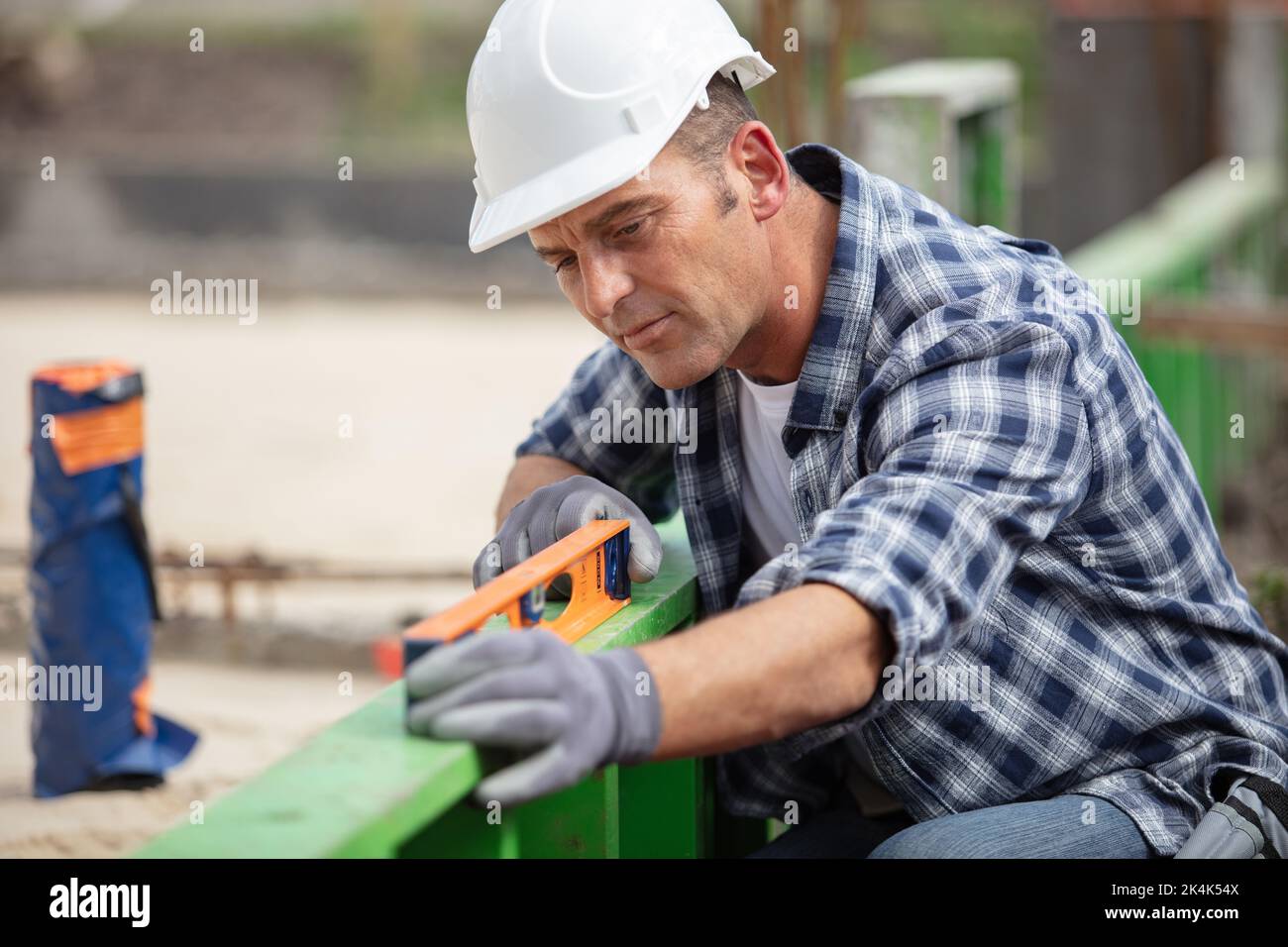plumber measuring slope of assembled sewage pipes using spirit level ...