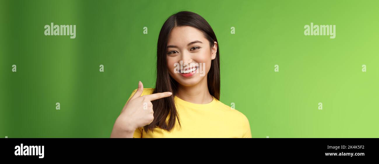 Close-up joyful proud asian assertive girl introduce herself, pointing ...