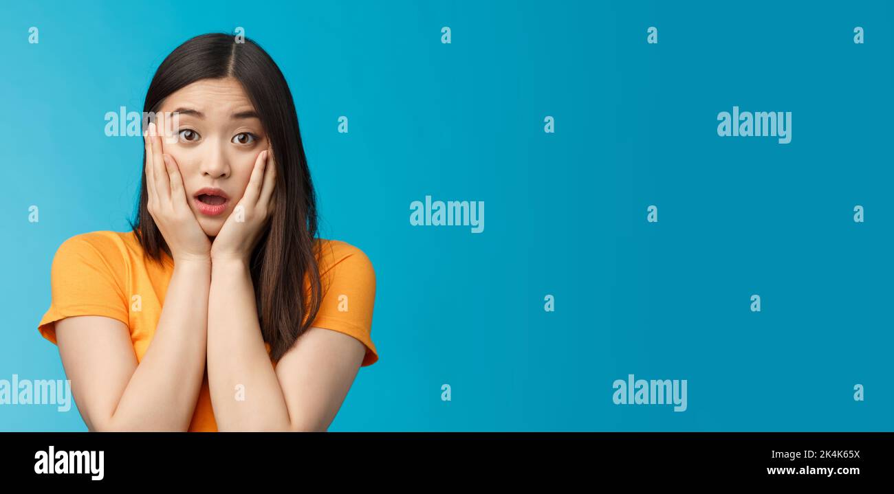 Close-up concerned shocked young timid asian girl gasping, dropping jaw ...