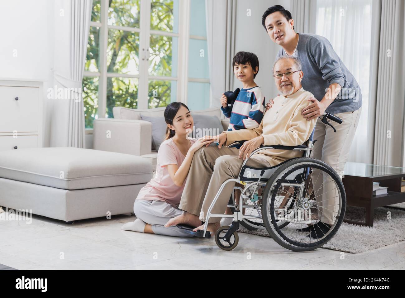 Happy Asian family of senior with beautiful daughter, her husband and grandson take care old man ...